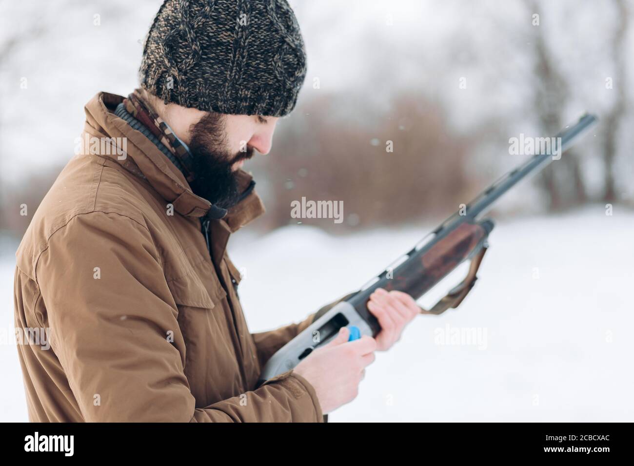 hunter loading the gun befor the hunting outdoors. side view close up ...