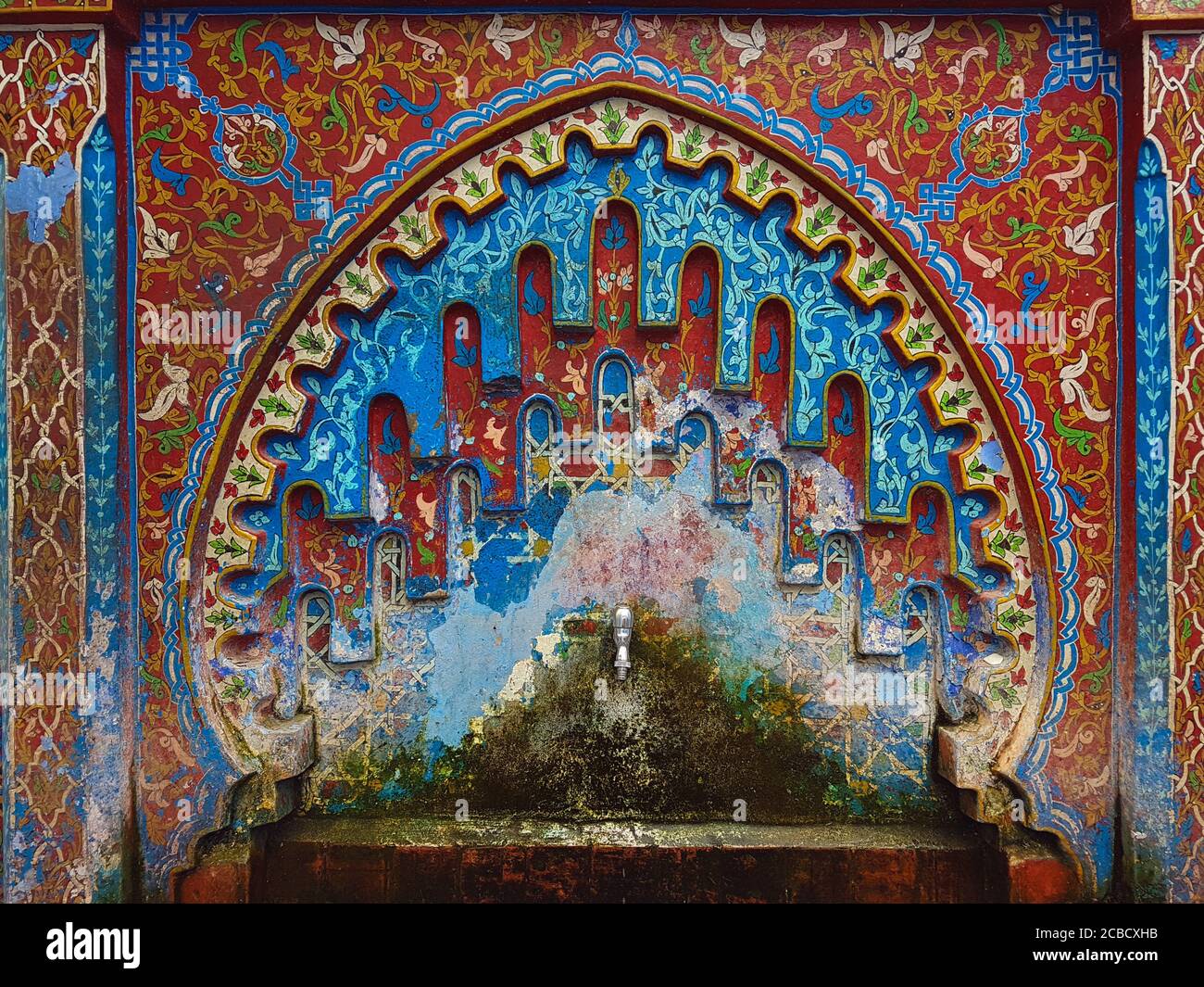 Ancient street water pipe with red mosaic wall, Chefchaouen medina ...