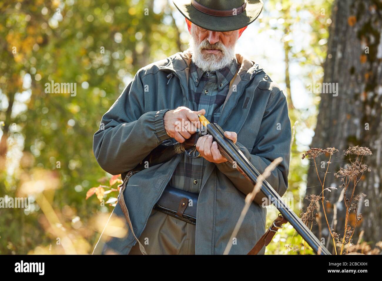 Senior hunter load rifle and going to shoot. Man in hunting casual ...