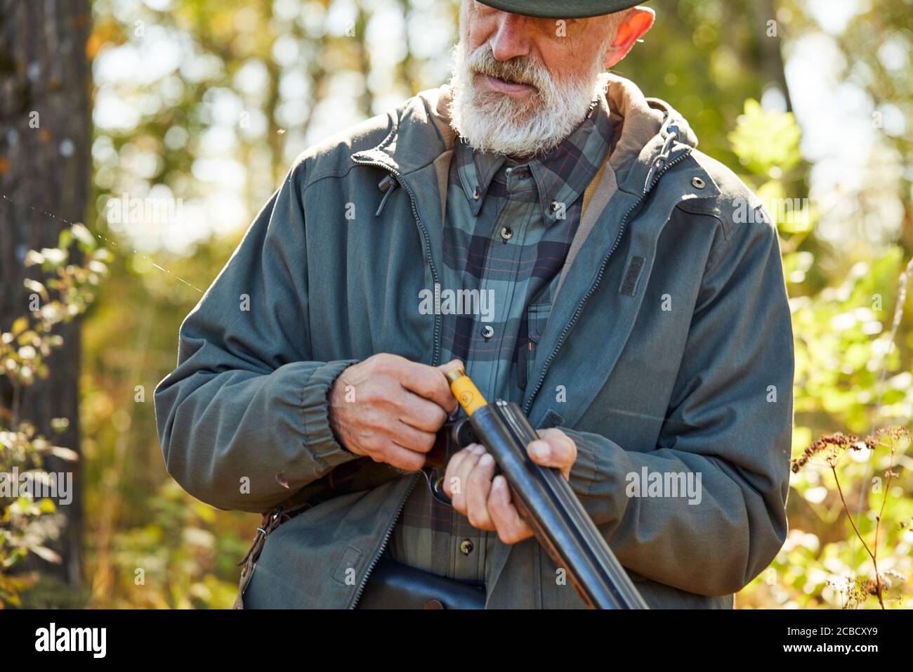 Senior hunter load rifle and going to shoot. Man in hunting casual ...