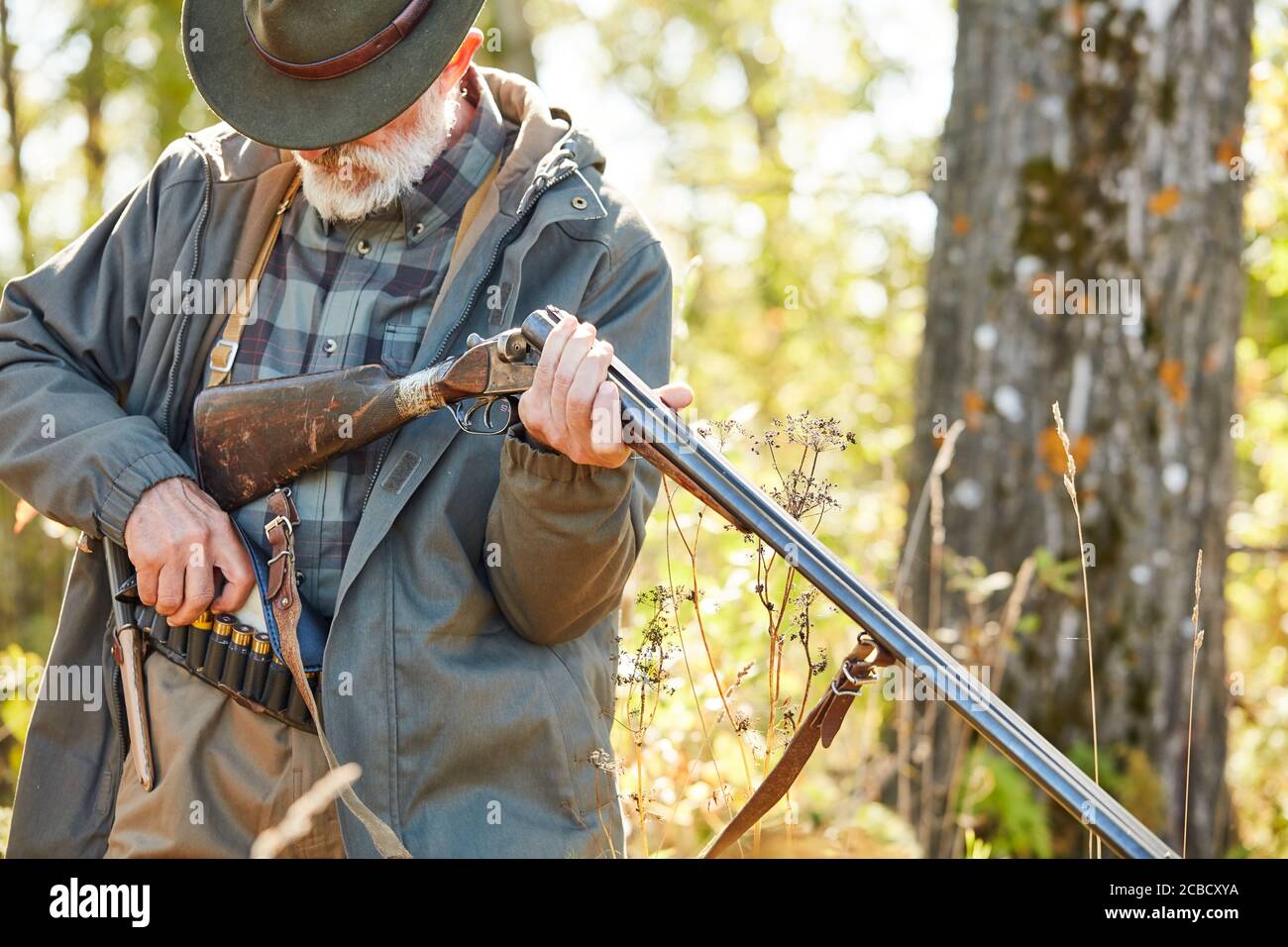 Senior hunter load rifle and going to shoot. Man in hunting casual ...