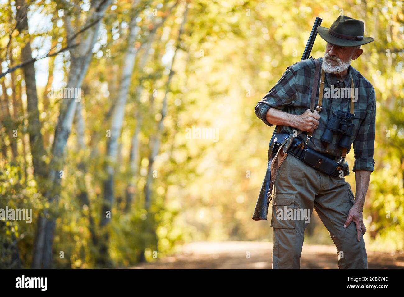 Bearded caucasian hunter wearing cowboy hat in search of trophy in ...