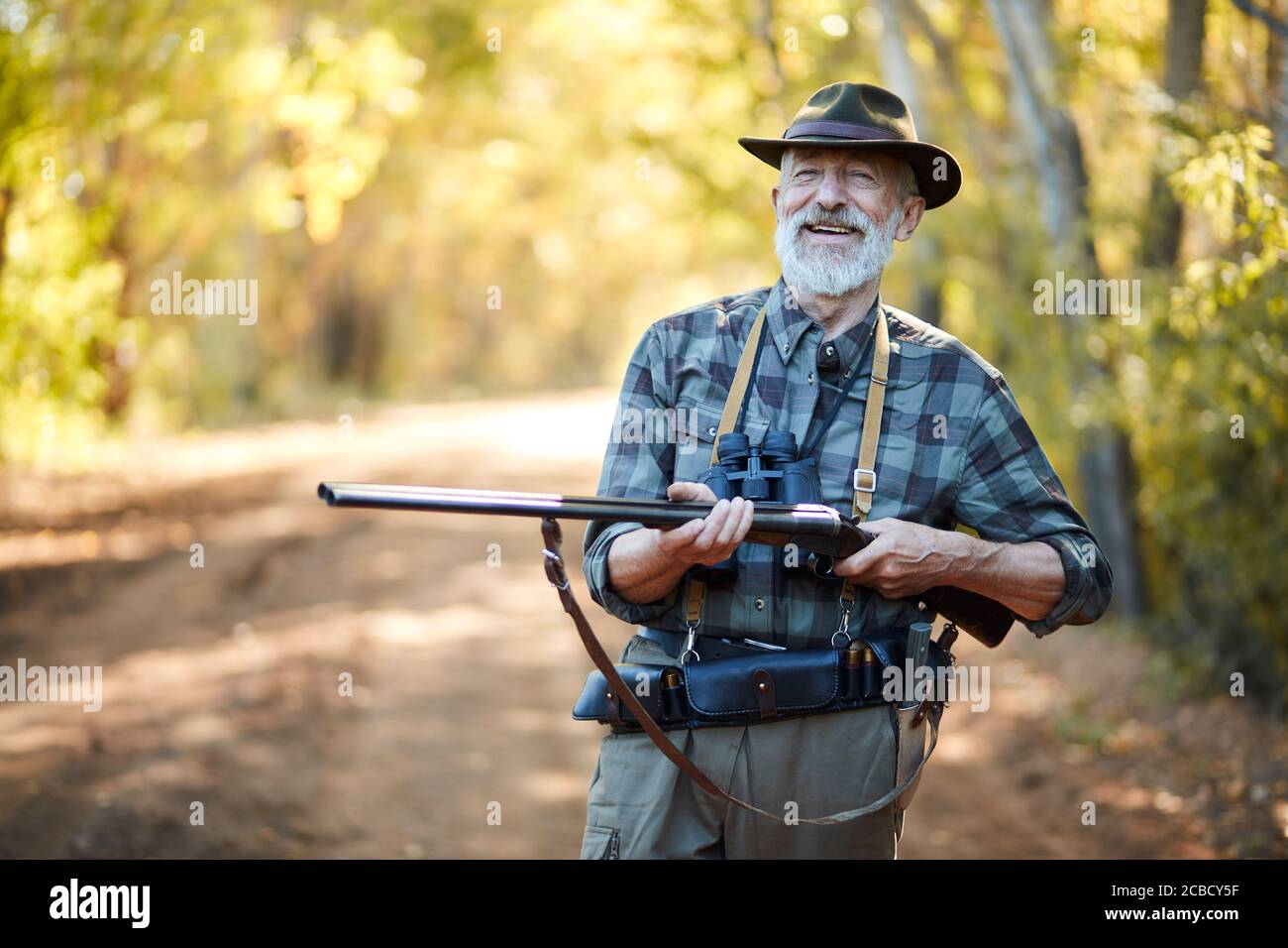 Smiling hunter hold shotgun, posing in forest. Hunting on birds Stock ...