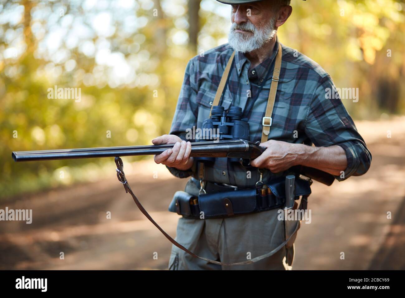 hunter man with grey beard holding gun to hunt on birds, ready to shoot ...