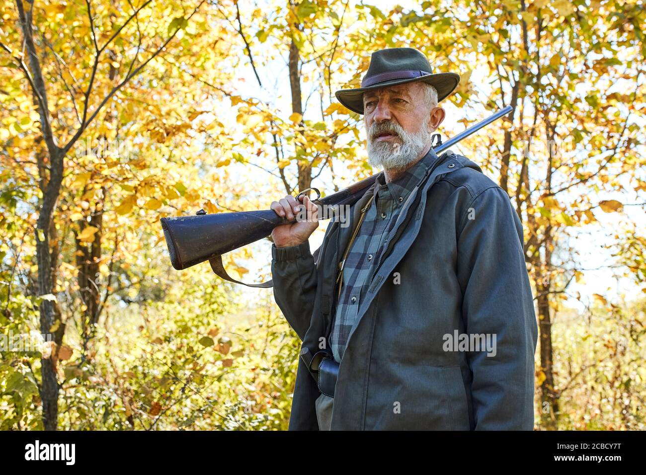 Older man stand looking for new trophy in forest, wearing hunting ...