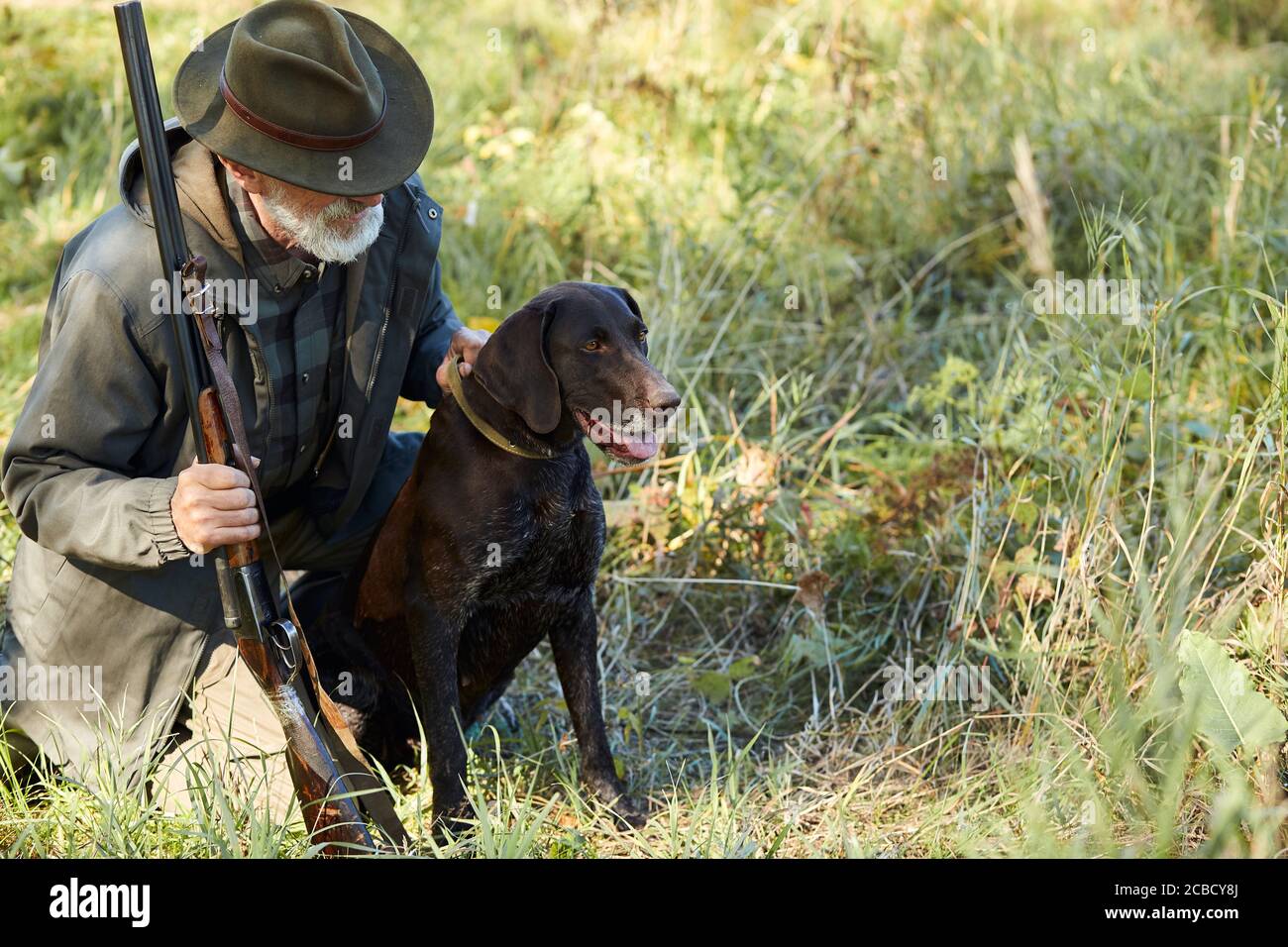 Senior hunter and his dog in forest, look for prey, hunting on wild ...