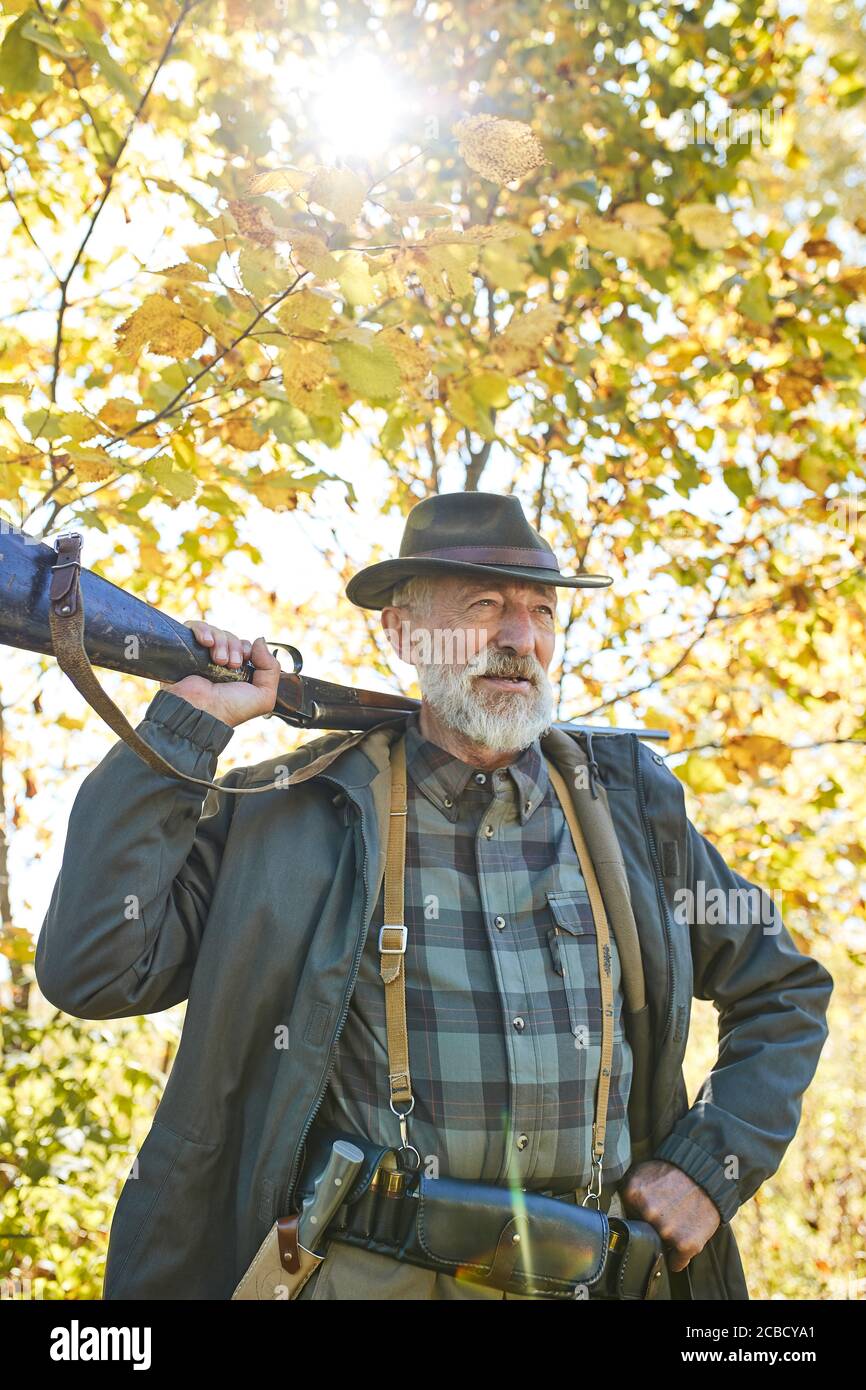 Older hunter spend leisure hunting. Brutal bearded man in hat, nature ...