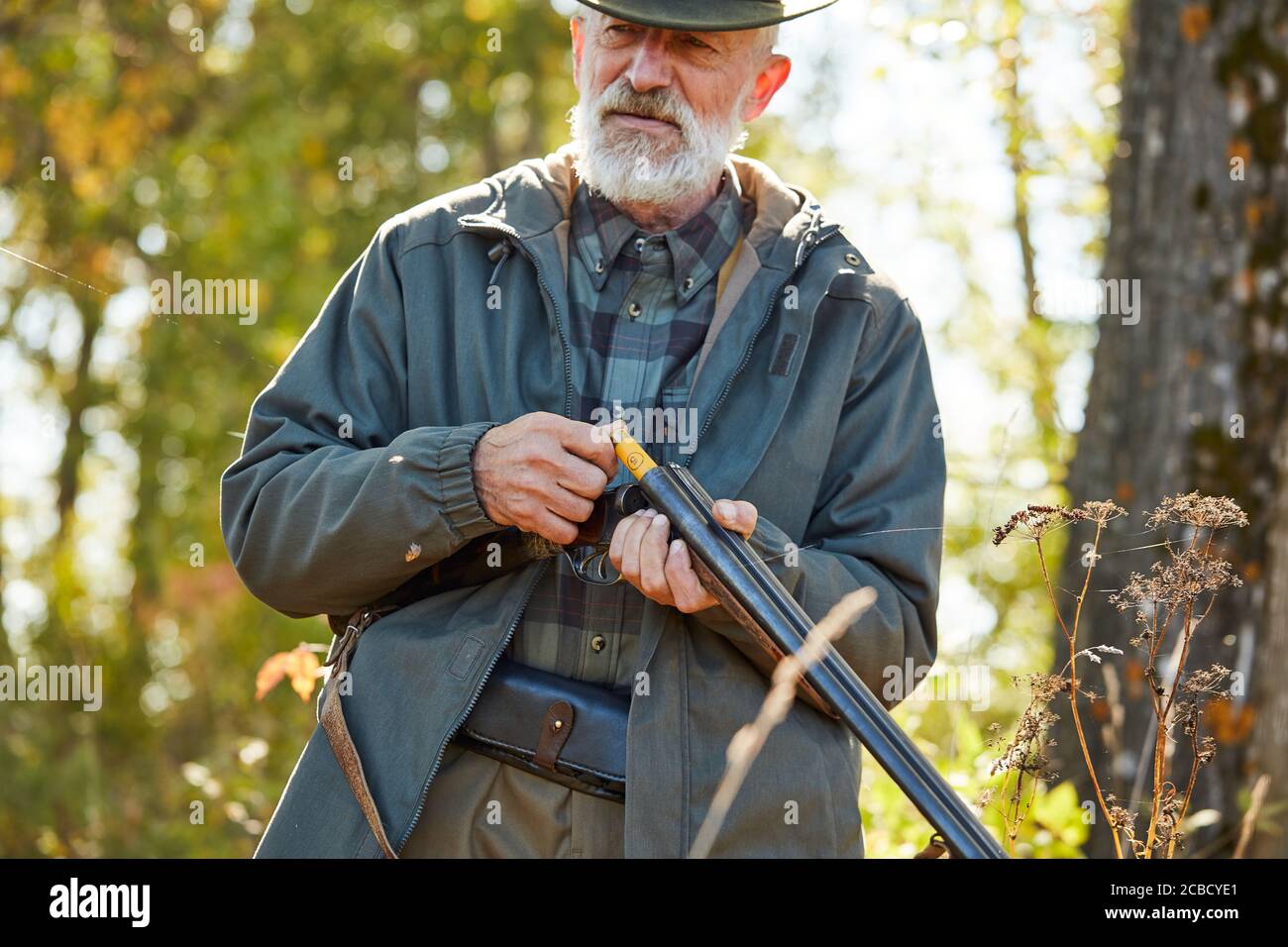 Older hunter load rifle and going to shoot. Man in hunting casual ...