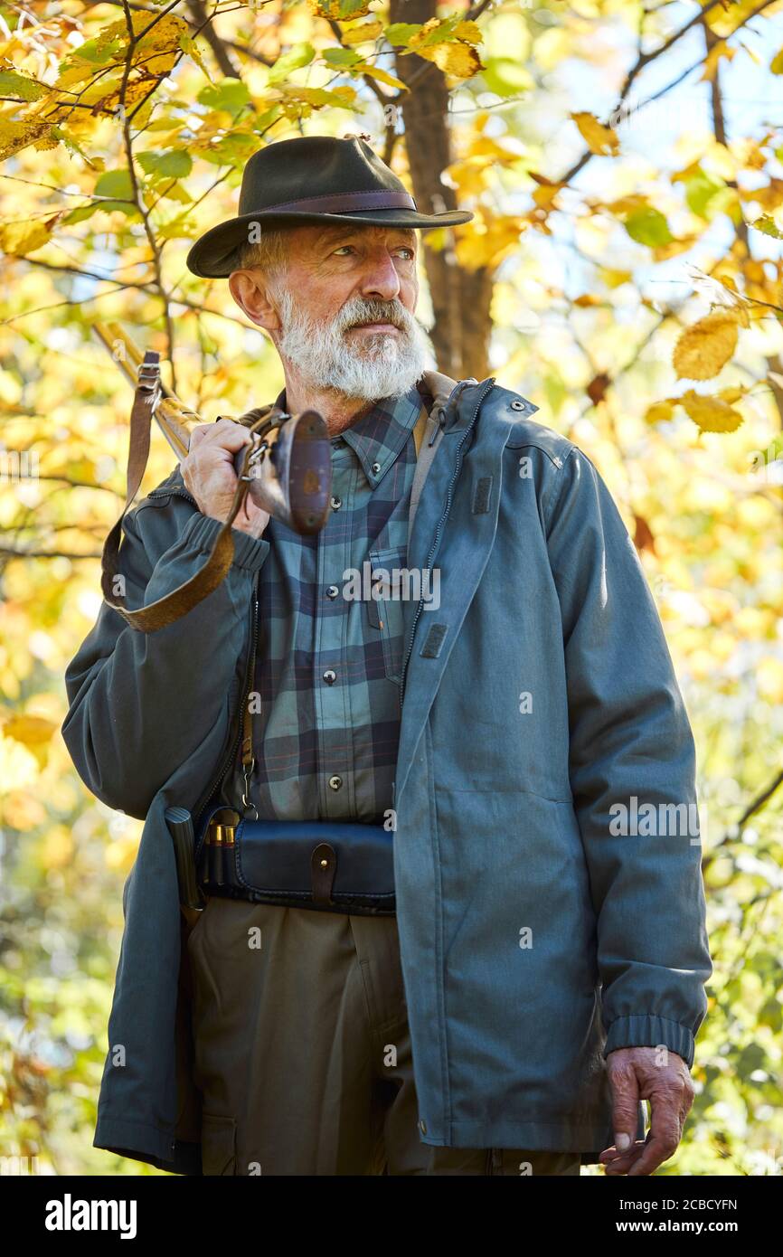 Distempered hunter man with grey beard look away with sadness. Forest ...