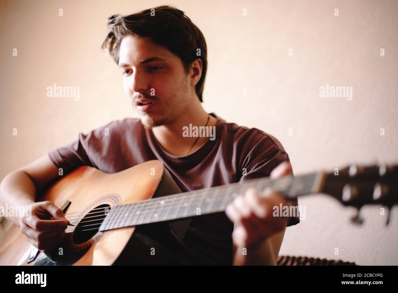 Young man singing while playing guitar at home Stock Photo - Alamy