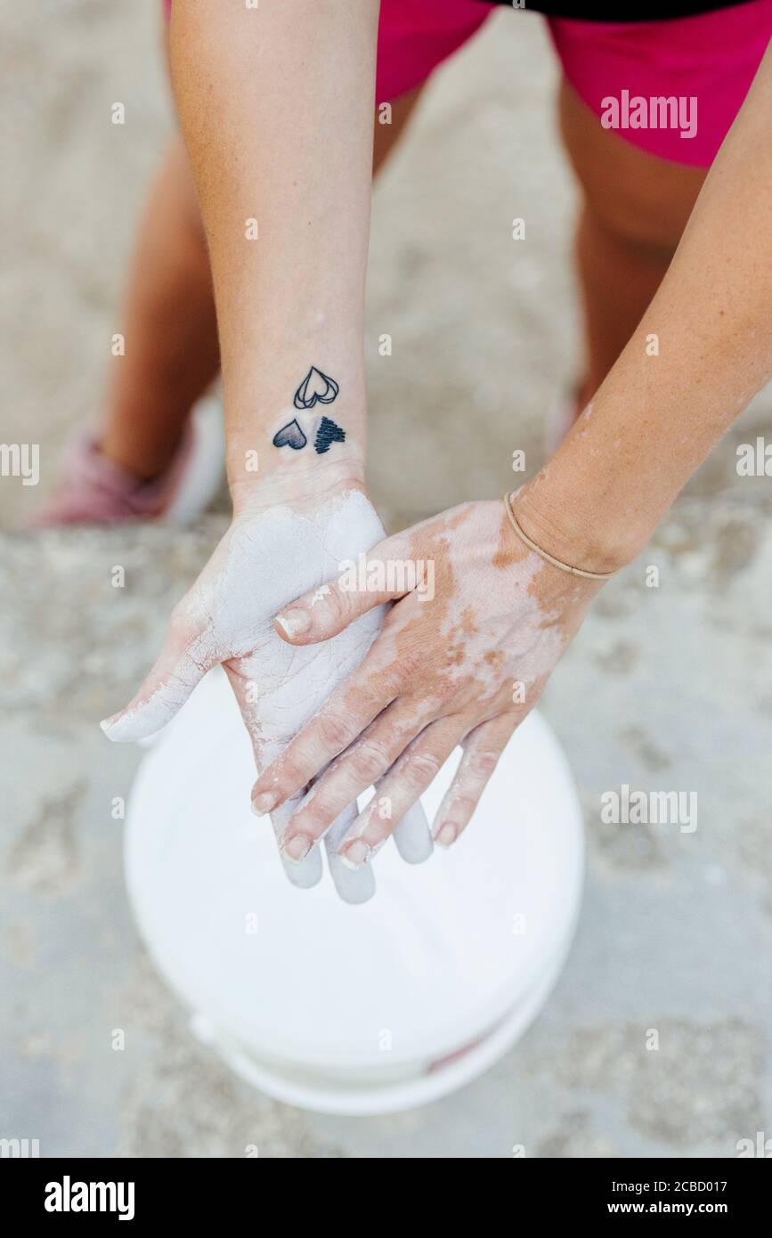 Woman putting chalk in her hands before practicing crossfit Stock Photo ...