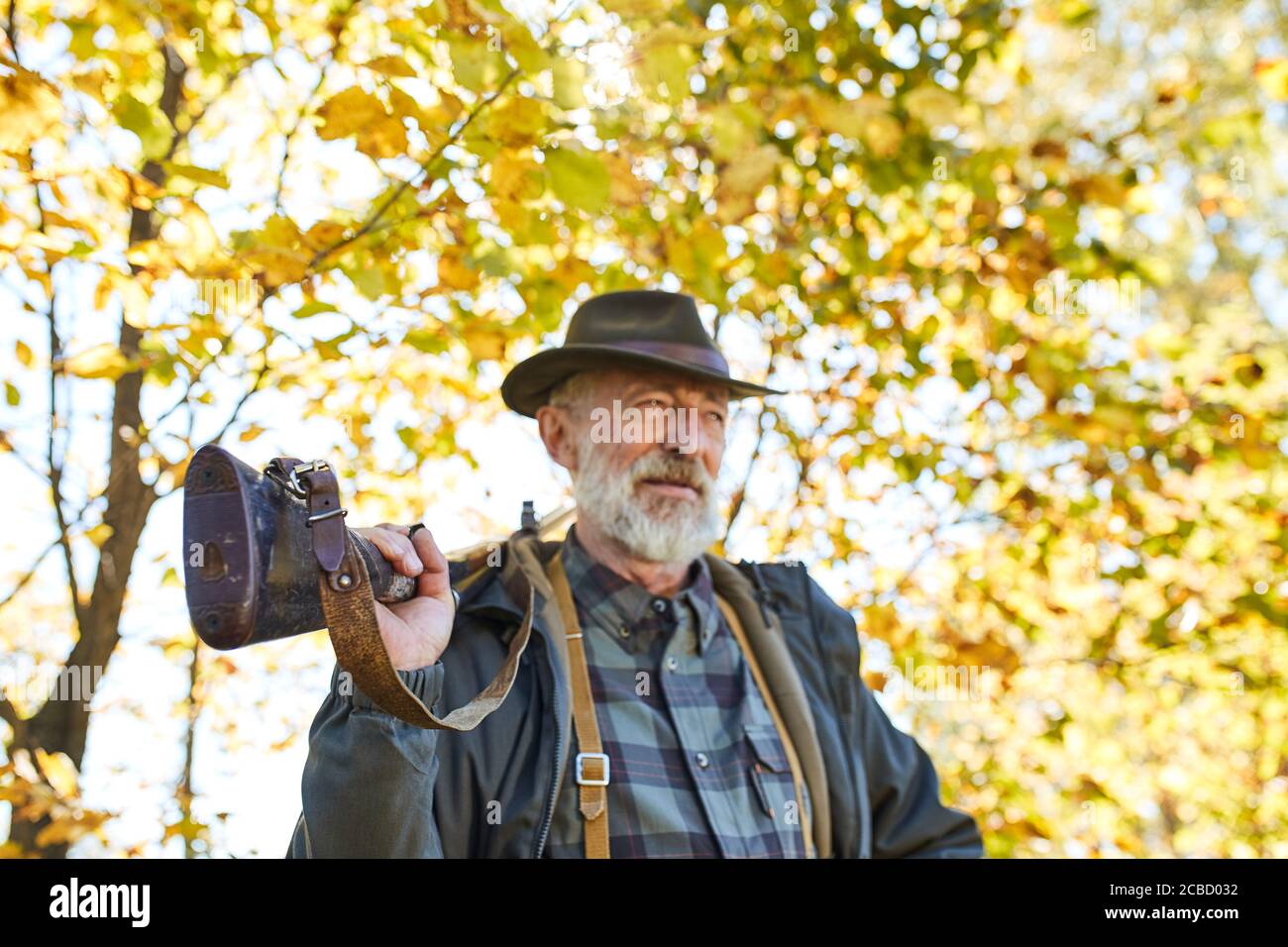 Tired hunter man carrying shotgun on shoulders, look away. Nature ...