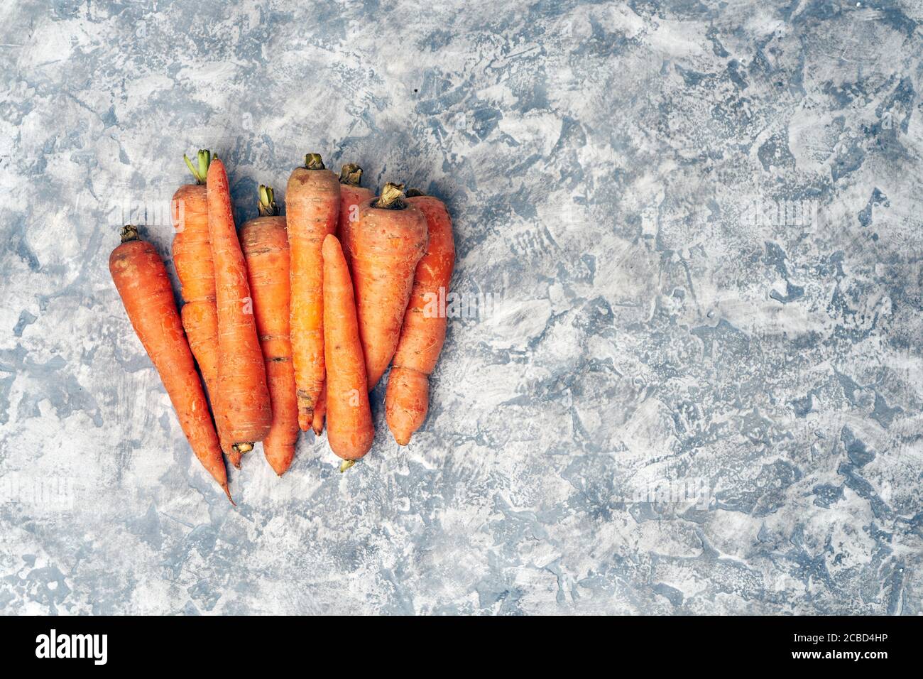Top view of fresh natural raw carrots on gray textured background with ...