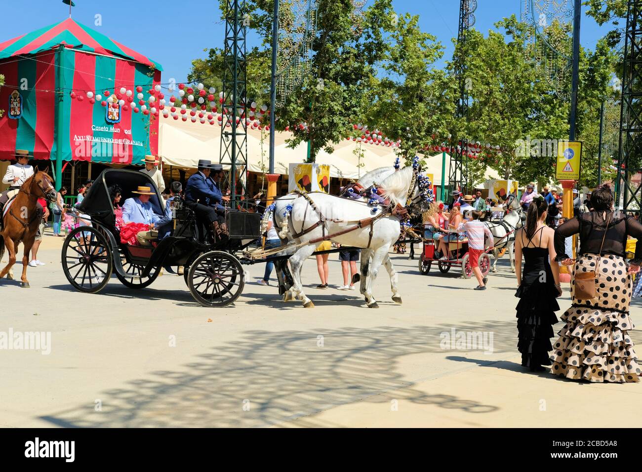 Horse drawn carriage and riders in traditional Spanish garb during the ...