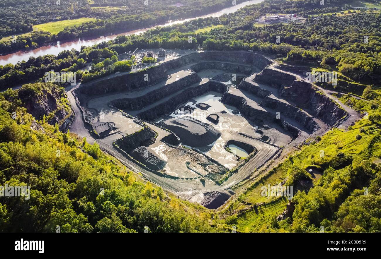 Aerial view of opencast mining quarry in the middle of the forest ...