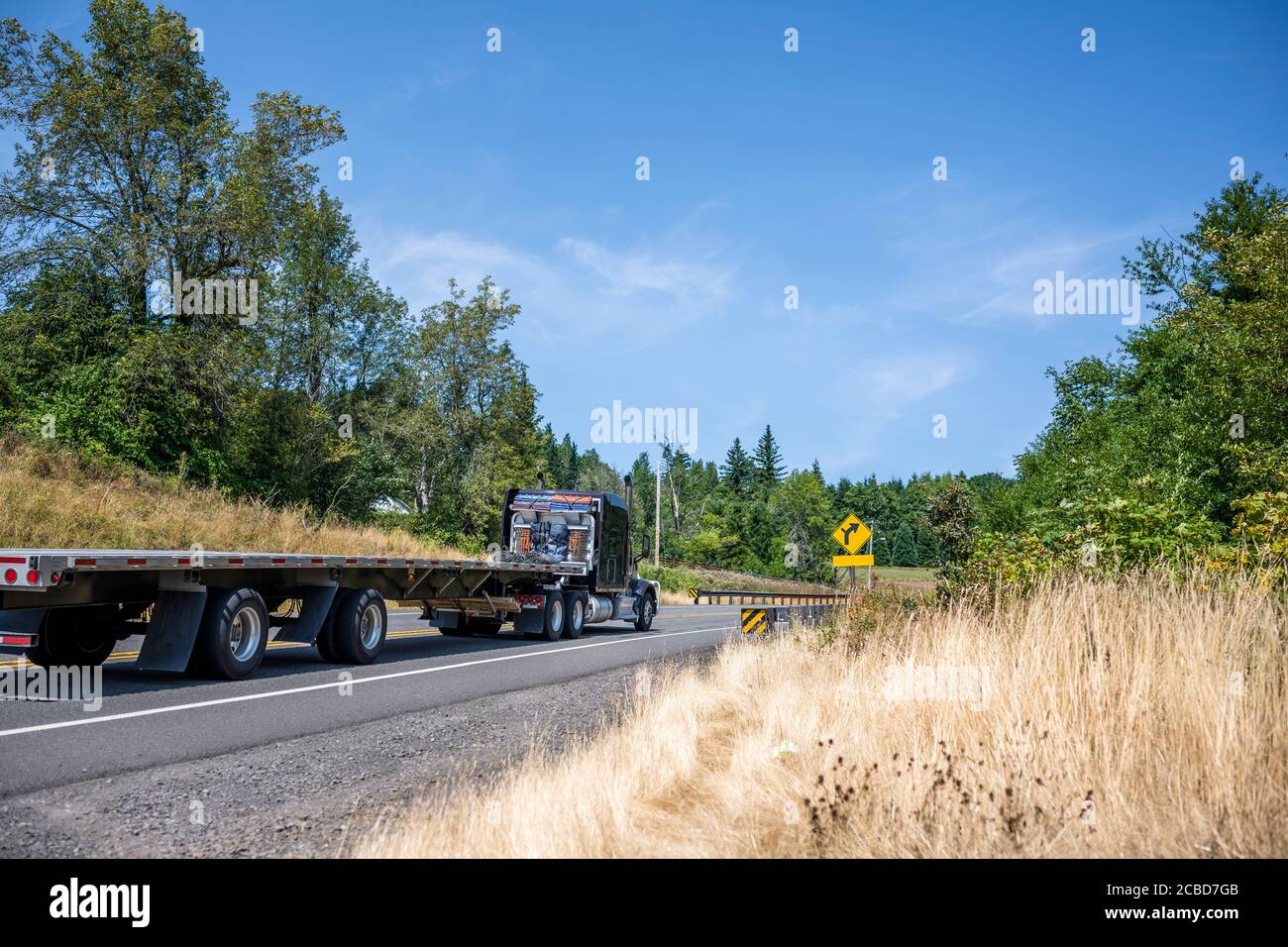 Black classic big rig semi truck with day cab transporting empty semi ...