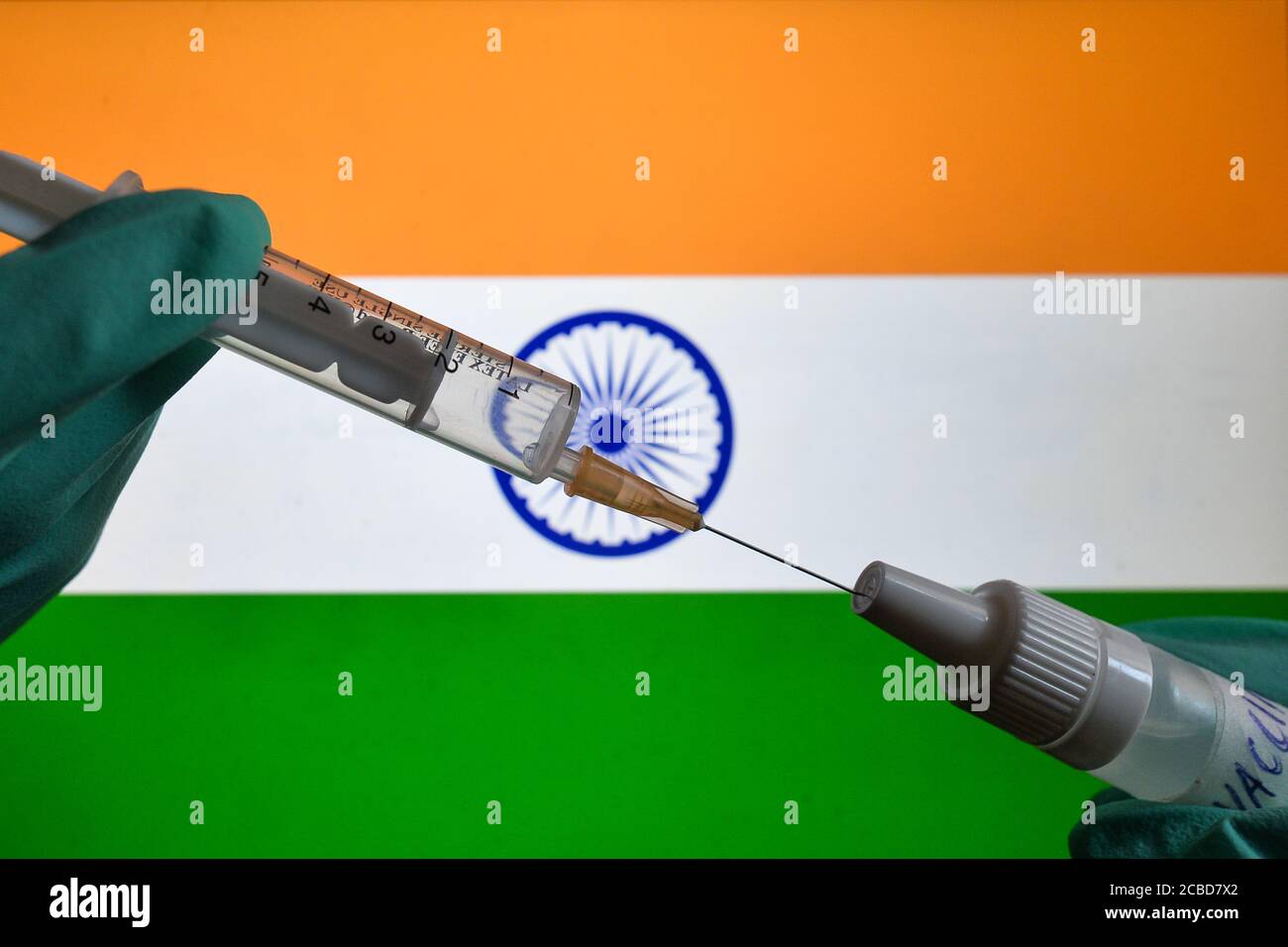 In this photo illustration a medical syringe and the flag of India in ...