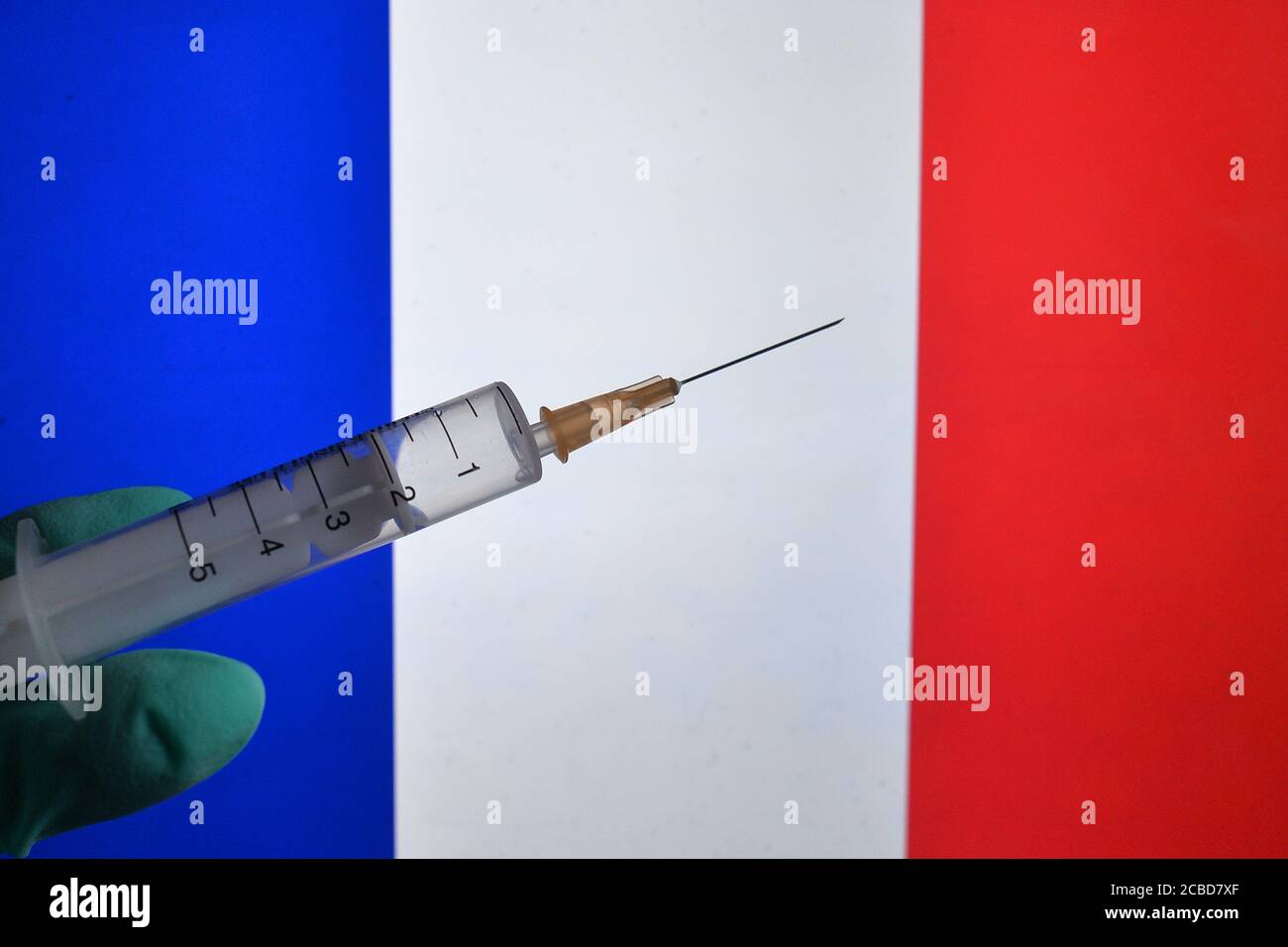 In this photo illustration a medical syringe and the flag of France in ...