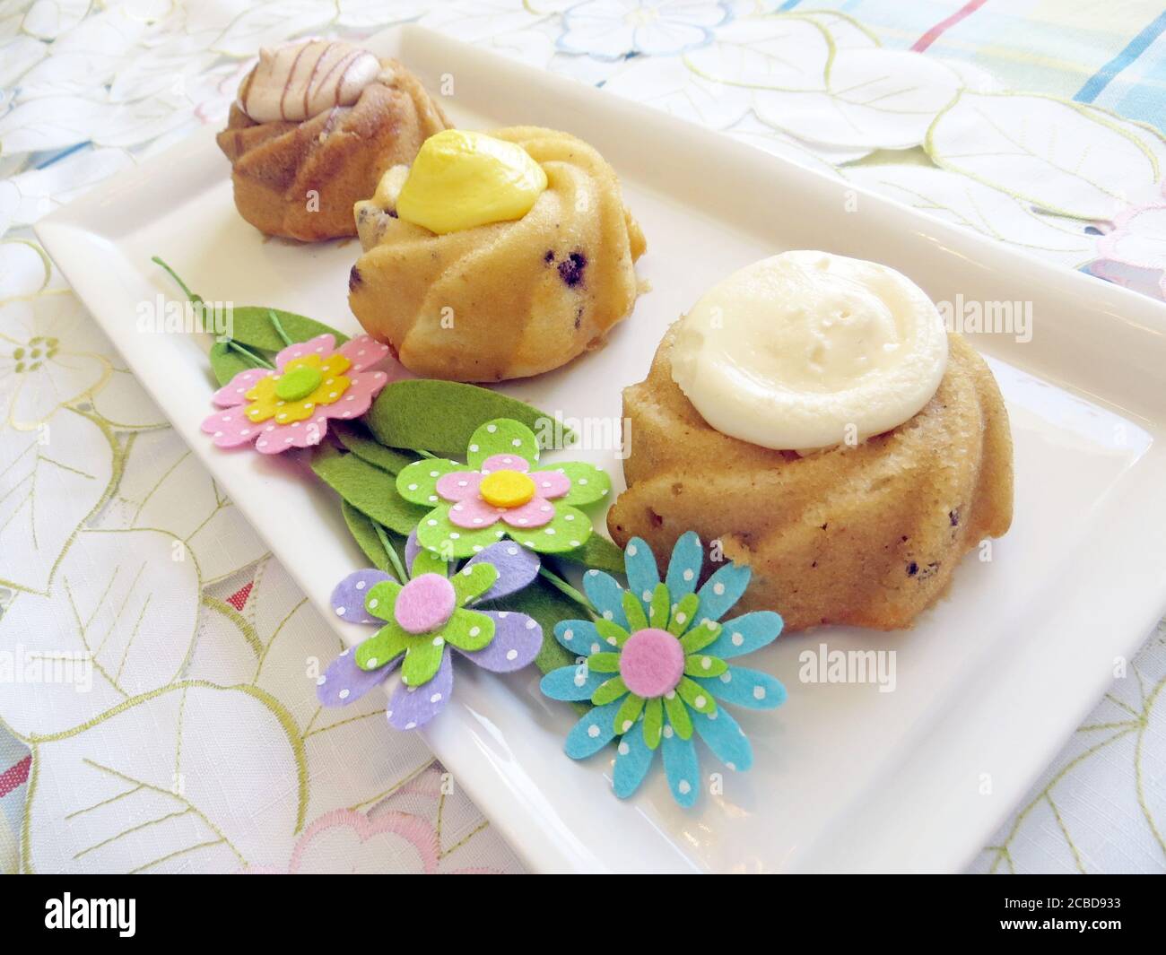 Three little cakes with a variety of frostings Stock Photo - Alamy