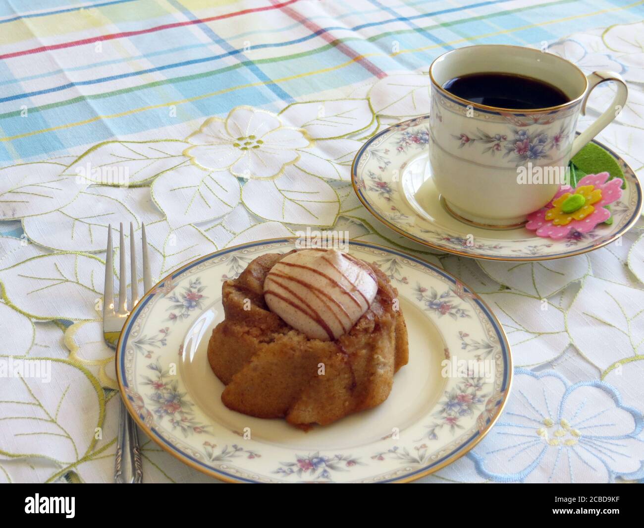 Small bundt cake with topping and a cup of coffee Stock Photo - Alamy