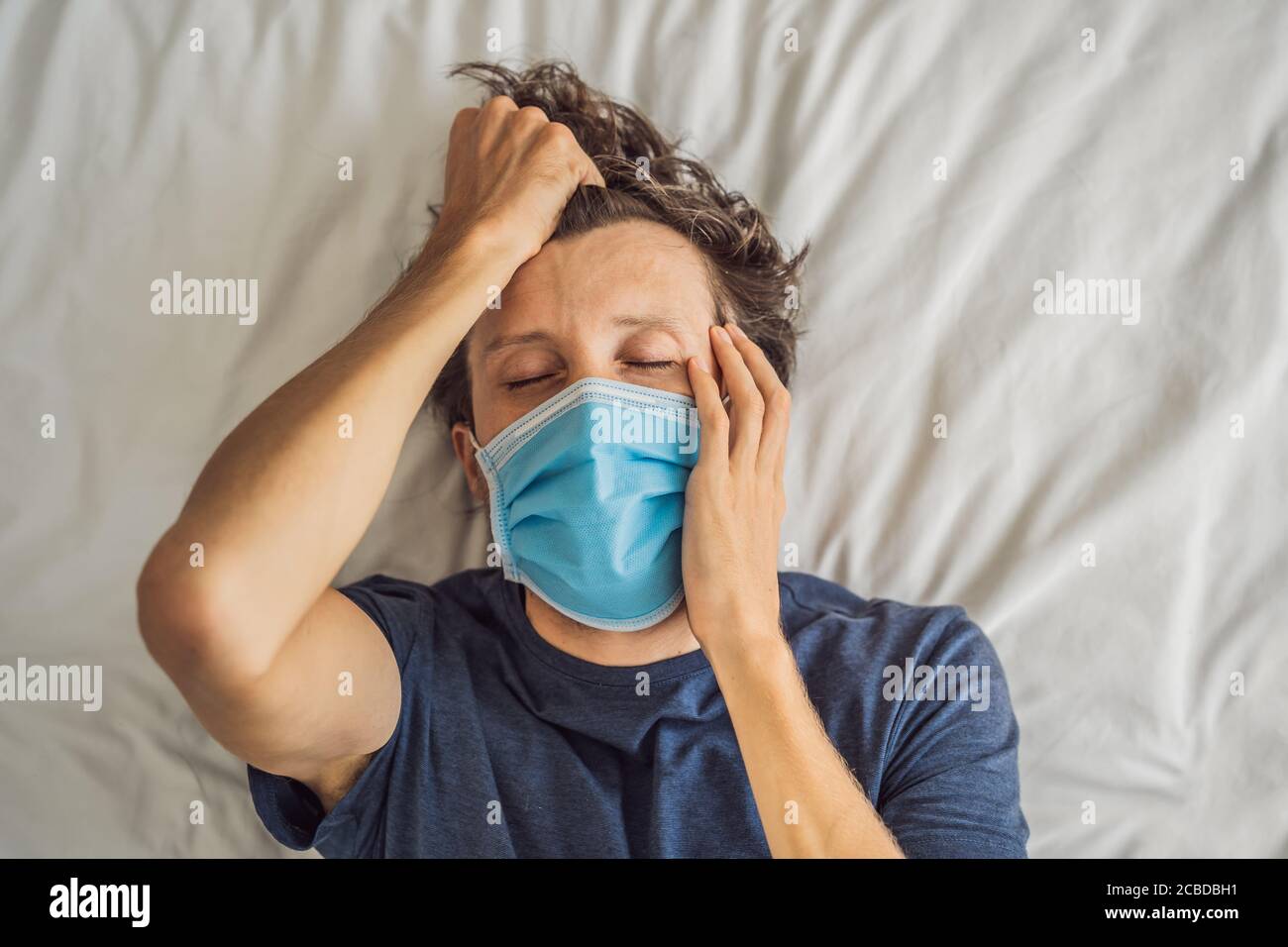 Extremly tired young man lying on the bed, home alone. self-isolation ...