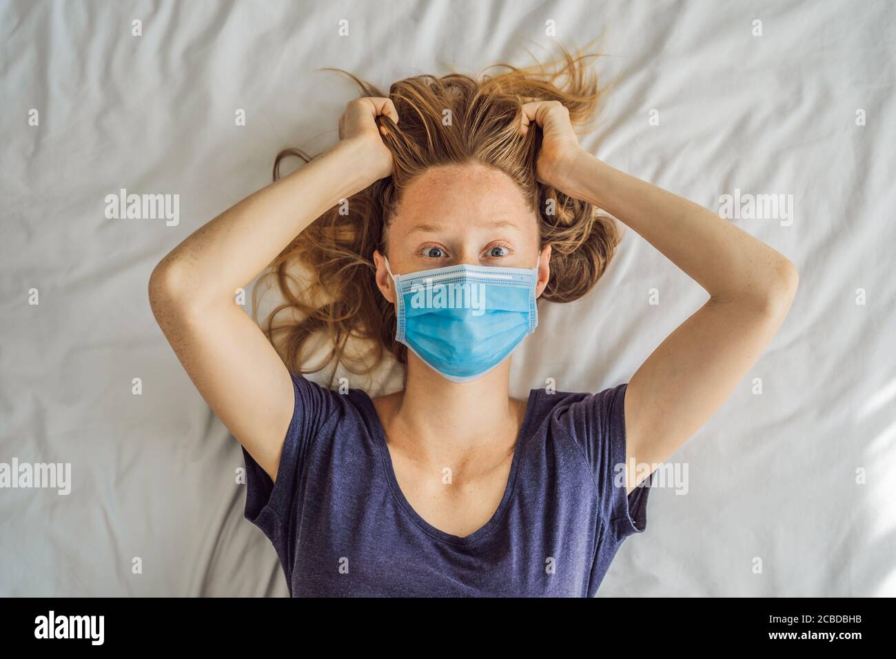 Extremly tired young woman lying on the bed, home alone. self-isolation ...