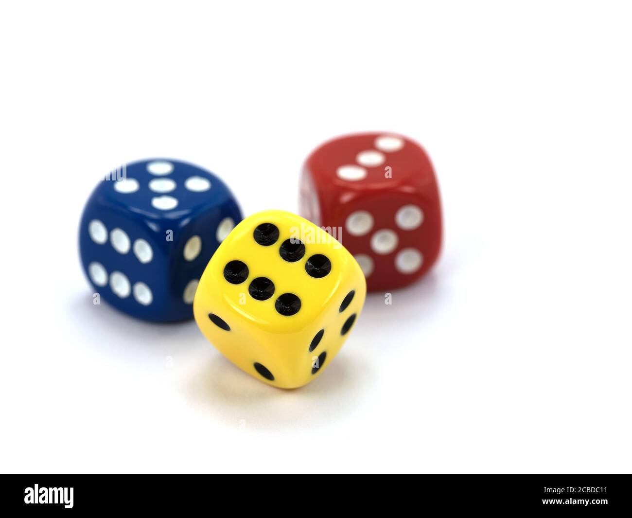 Three colorful dice against white background Stock Photo - Alamy