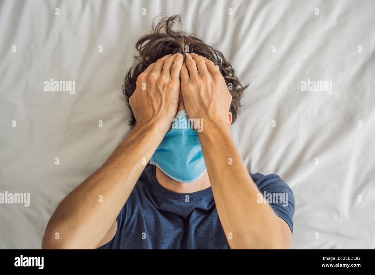 Extremly tired young man lying on the bed, home alone. self-isolation ...