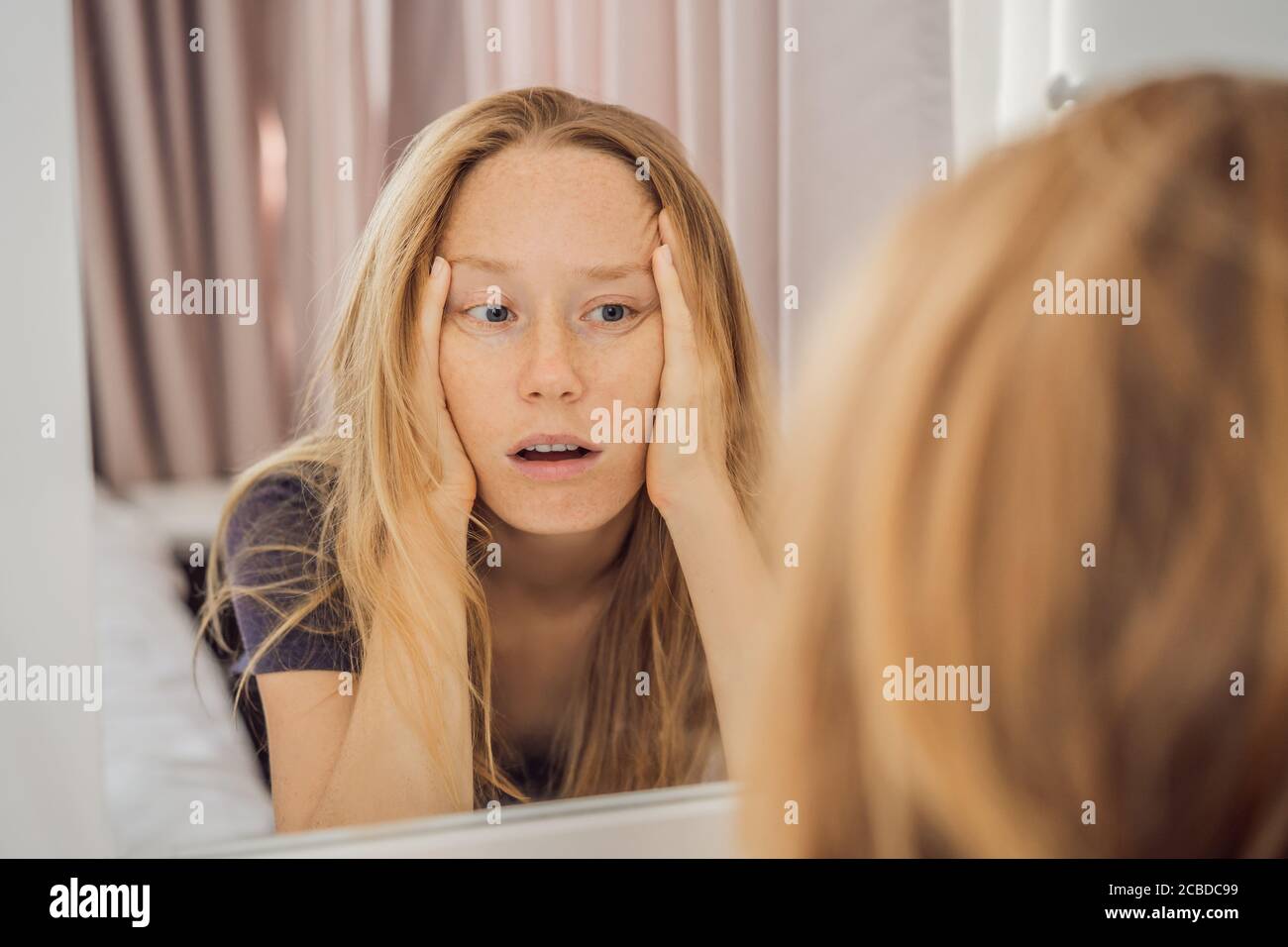 Extremly tired young woman looking at himself in the mirror, home alone ...