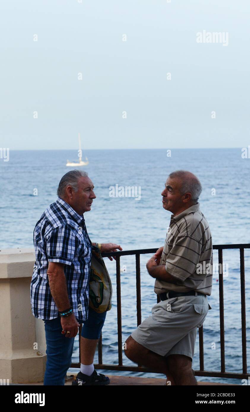 Maltese men chatting on the waterfront promenade of Sliema, Malta Stock ...
