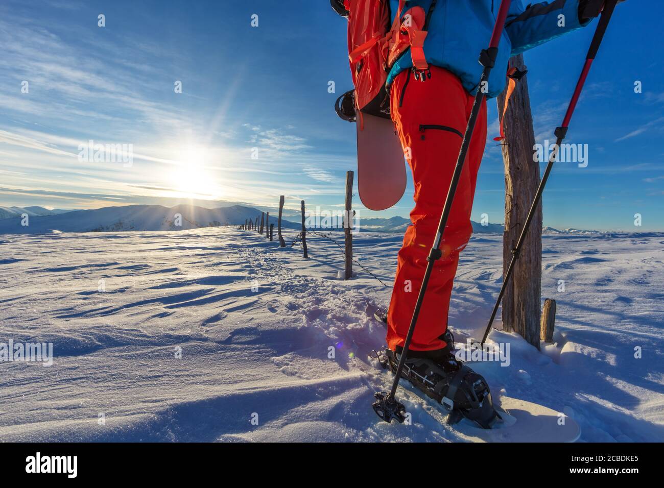Closeup of snowboarder walking on snowshoes in powder snow. European ...