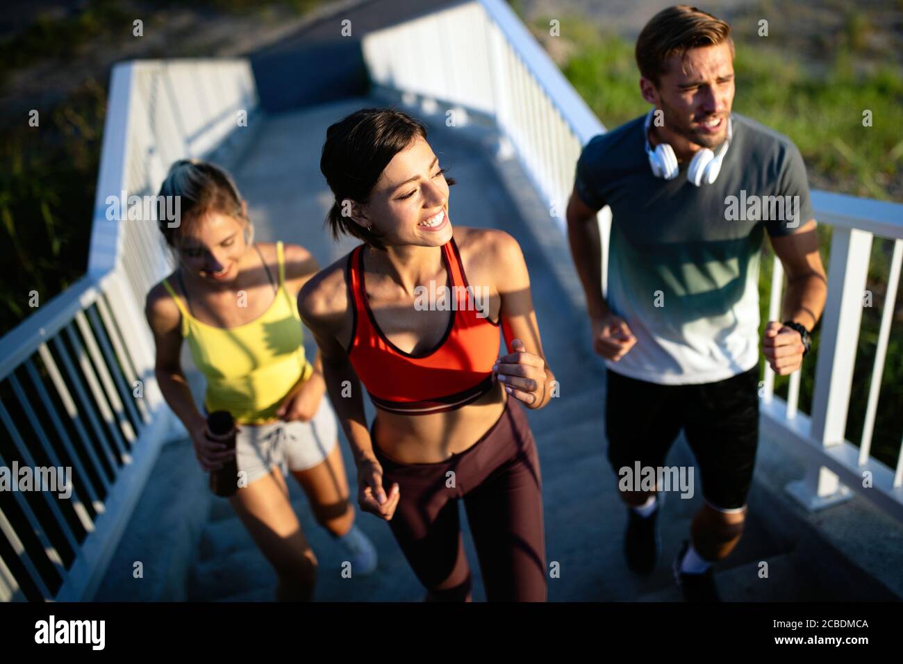 Fitness, sport, people and running concept. Happy fit friends running ...