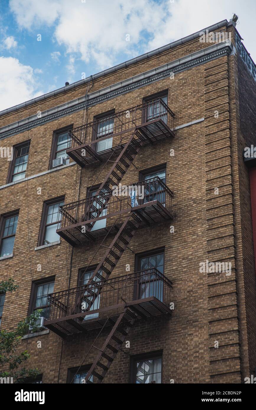 Vertical shot of a brown brick building facade with connected balconies ...