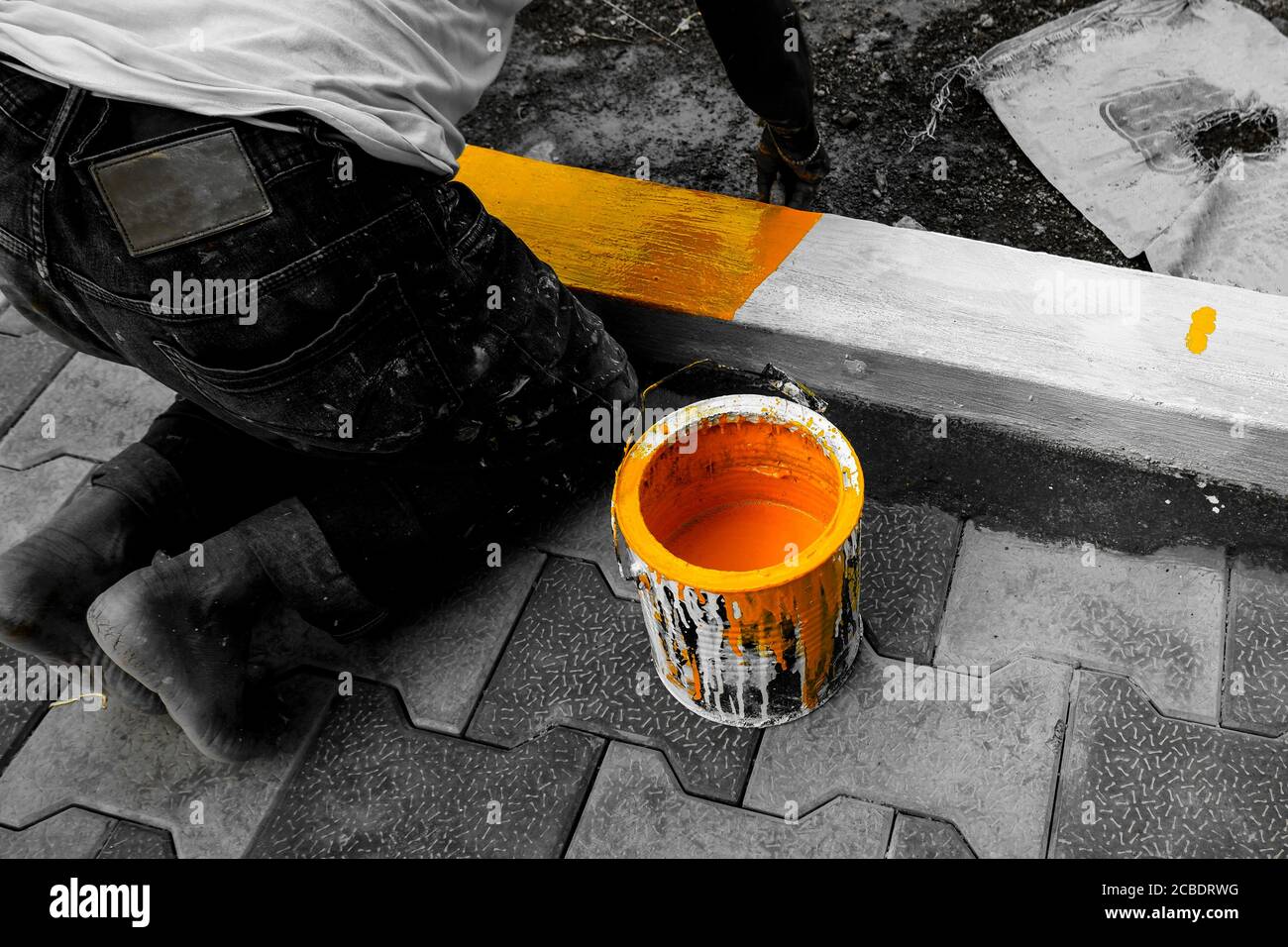 a man painting yellow color on walking path in park Stock Photo - Alamy