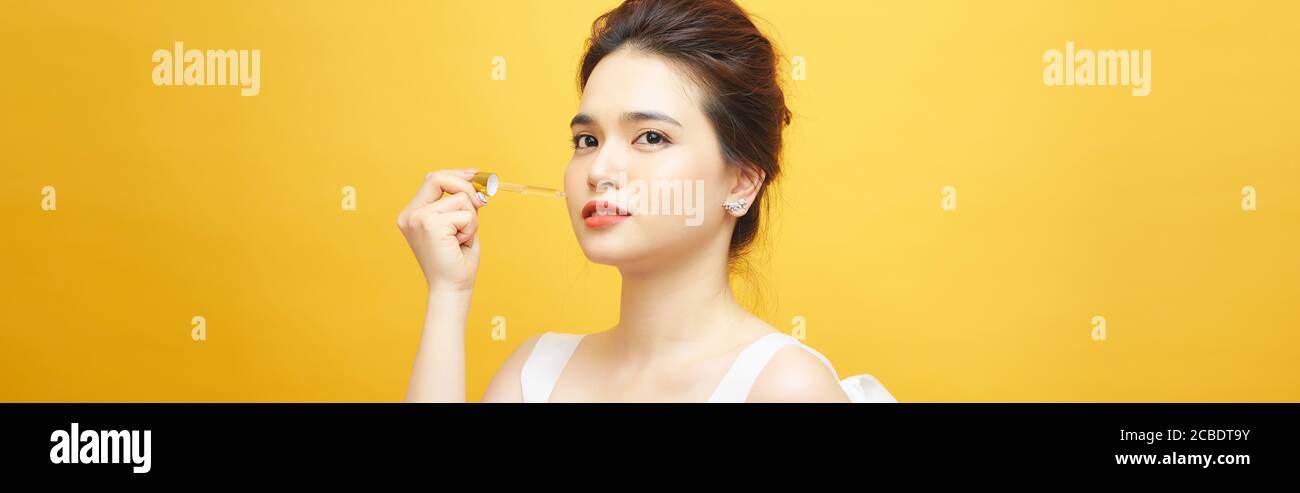 Beautiful model applying a cosmetic skin serum on her skin Stock Photo ...