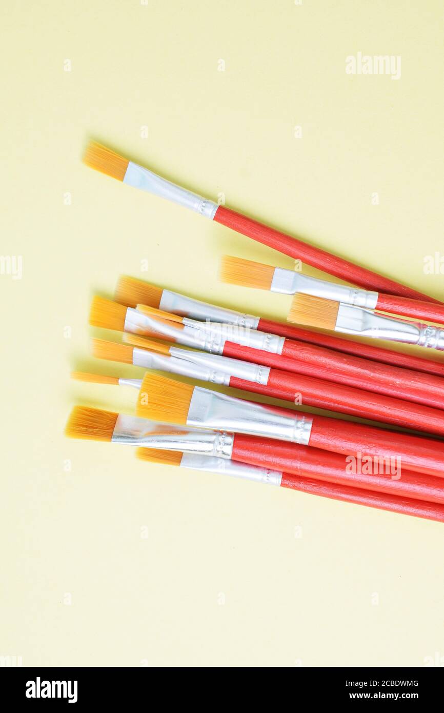 Set of paint brushes on yellow background Stock Photo - Alamy