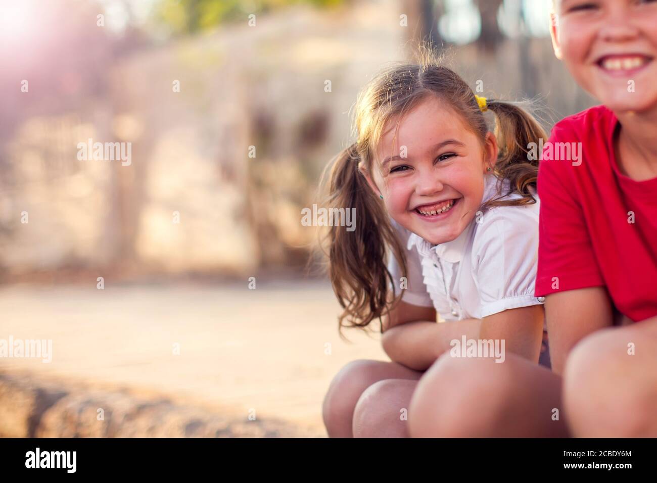 Smiling pupils sitting together outdoor. Children and emotions concept ...