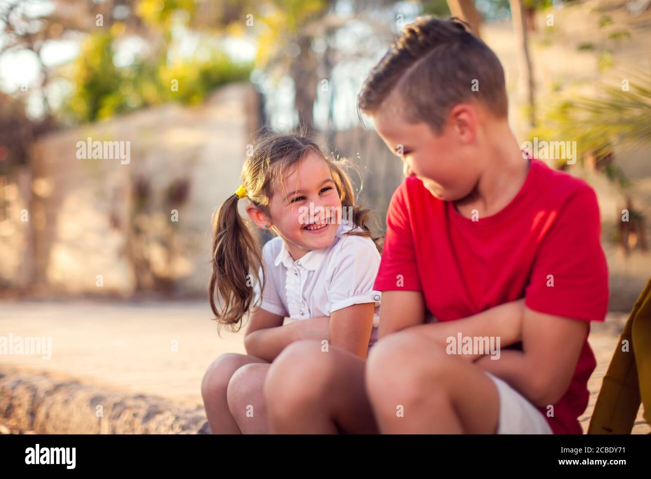 Smiling pupils sitting together outdoor. Children and emotions concept ...