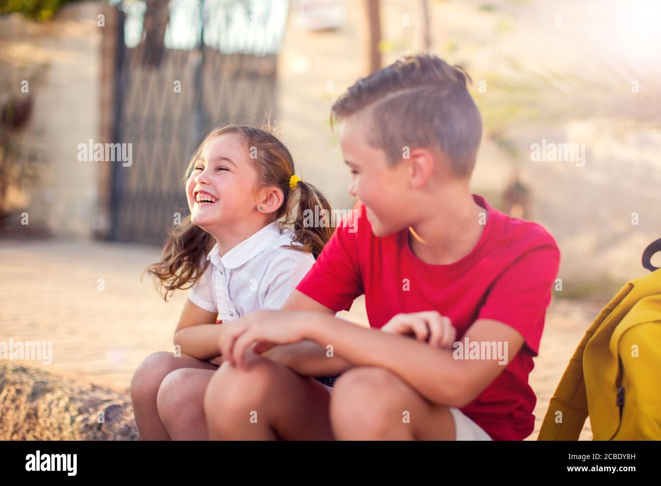 Smiling pupils sitting together outdoor. Children and emotions concept ...
