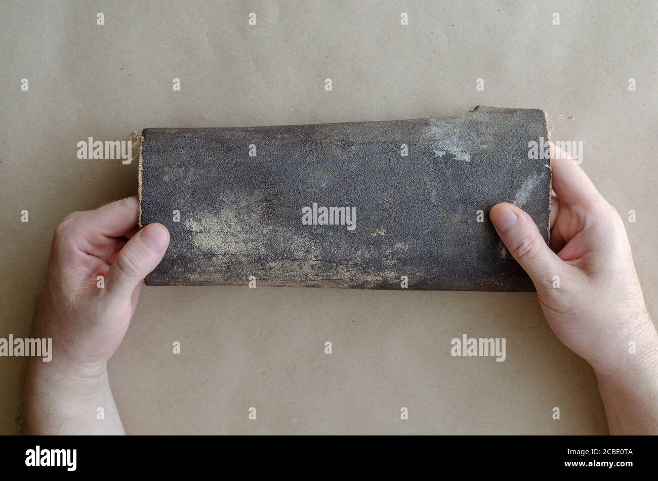 Caucasian man is holding an old sandpaper. The hand of a middle-aged ...