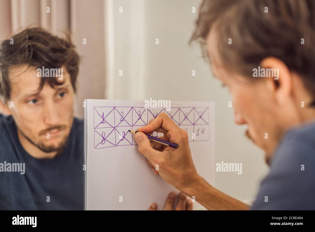 Extremly tired young woman fills in the self-isolation calendar for 14 ...