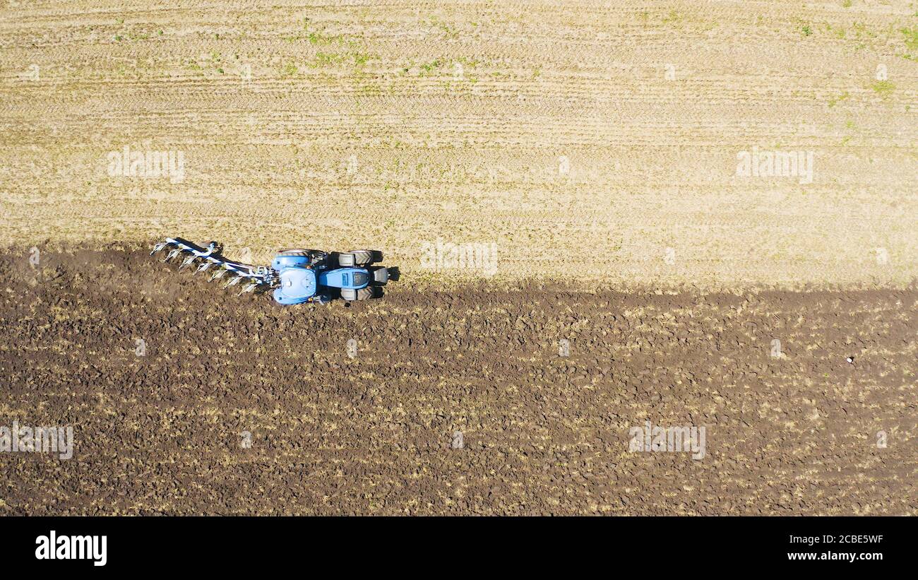 Aerial top view of a tractor on an industrial field Stock Photo - Alamy