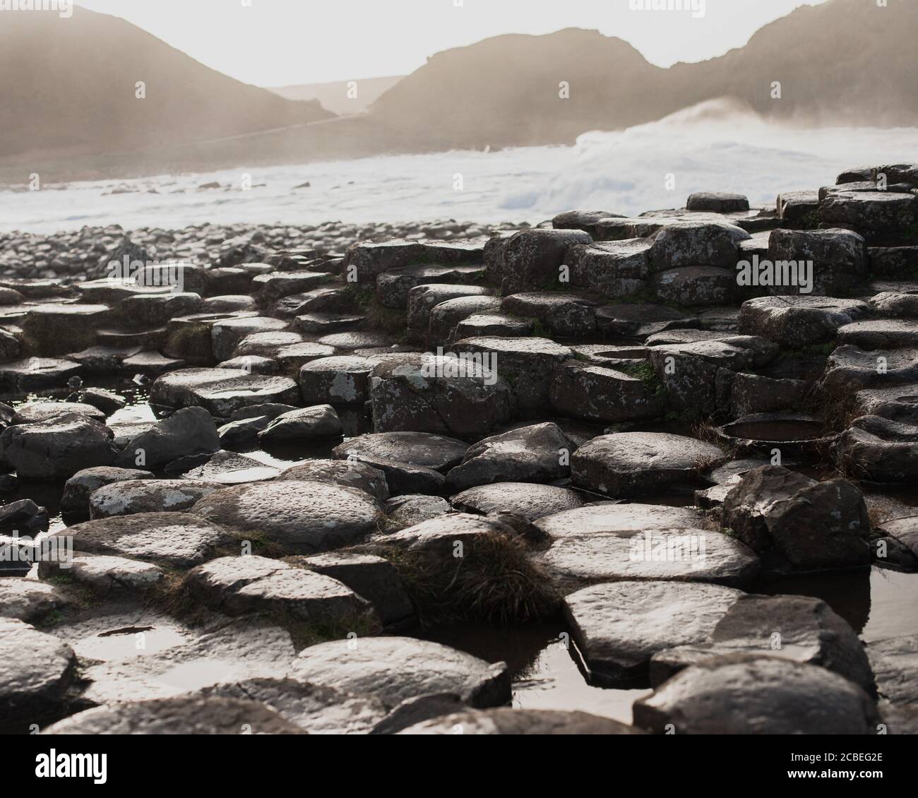 Rocks of Giant's Causeway on Belfast, Ireland with mountains and sea ...