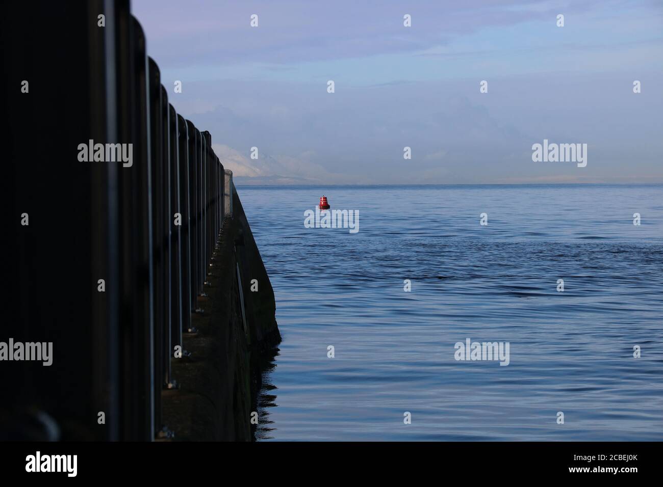 Red buoy and jetty at a coastal location in winter Stock Photo - Alamy