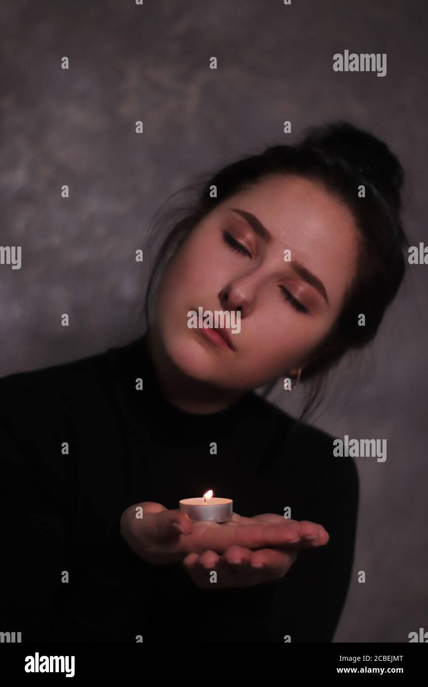 sad brunette girl almost burst into tears holding candle Stock Photo ...
