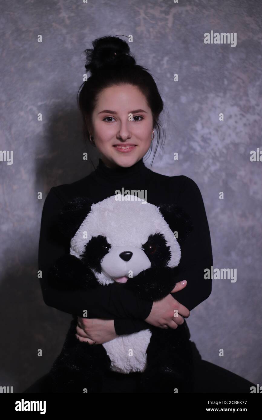 brunette girl holding big fluffy toy panda Stock Photo - Alamy