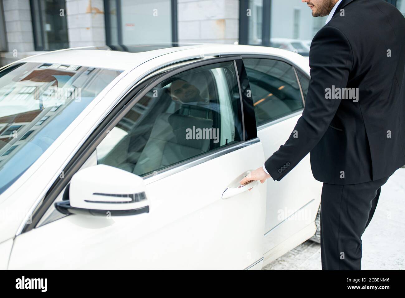 side view of cropped man opening door of executive car at street Stock ...