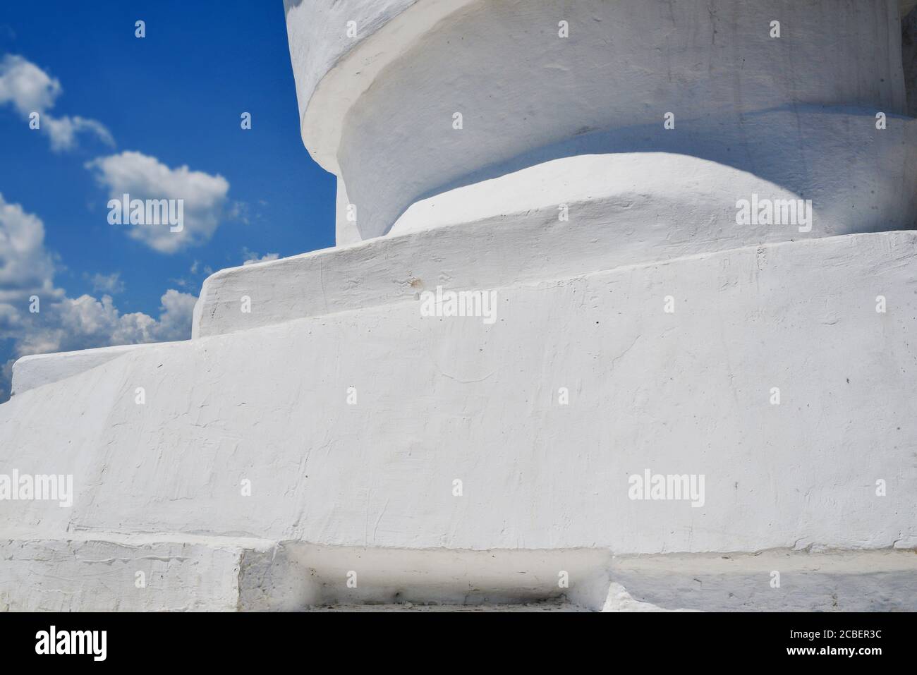 Photo of white statue against the sky. Part of a white statue against ...