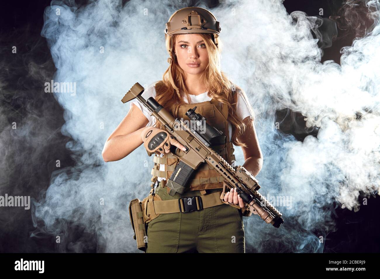 Woman soldier in military camouflage uniform protected with helmet ...