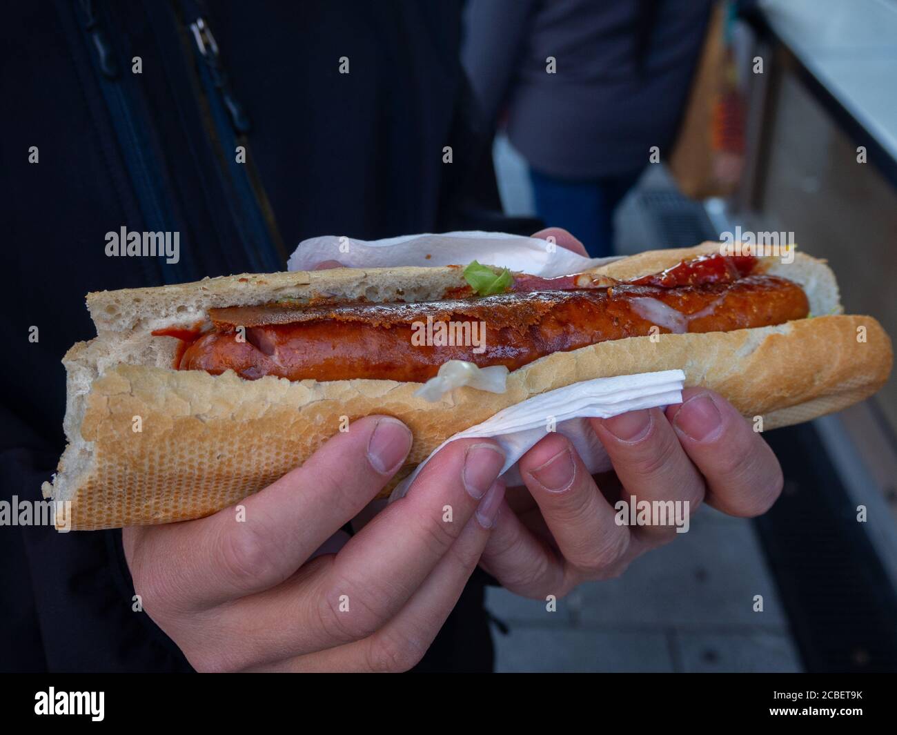 Delicious Austrian-style hot dog in human hands Stock Photo - Alamy